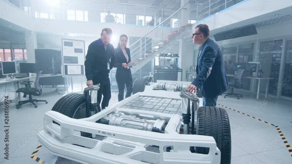 Automotive Design Engineers Talking while Working on Electric Car ...
