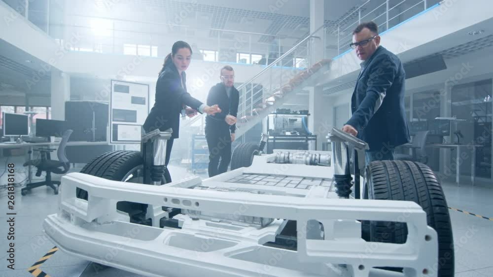 Automotive Design Engineers Talking while Working on Electric Car ...