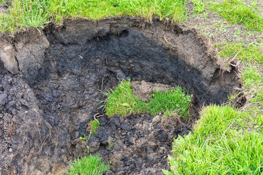 Landslide debris of water-laden masses of soil with the green grass on ...