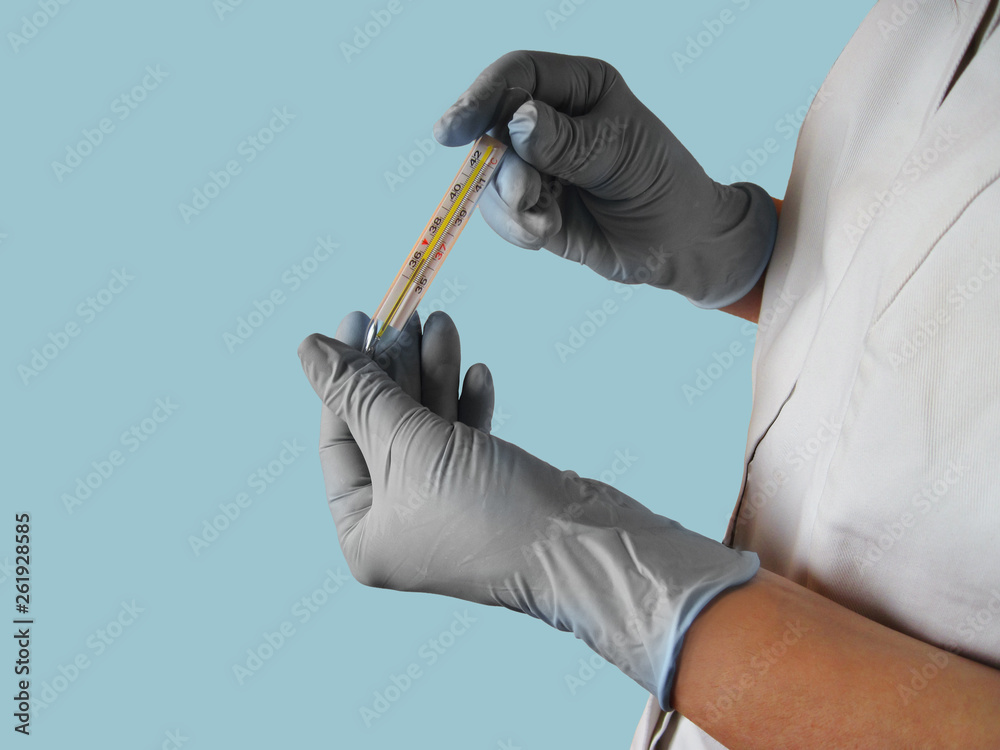 Temperature measuring. Two hands in latex gloves hold a thermometer ...