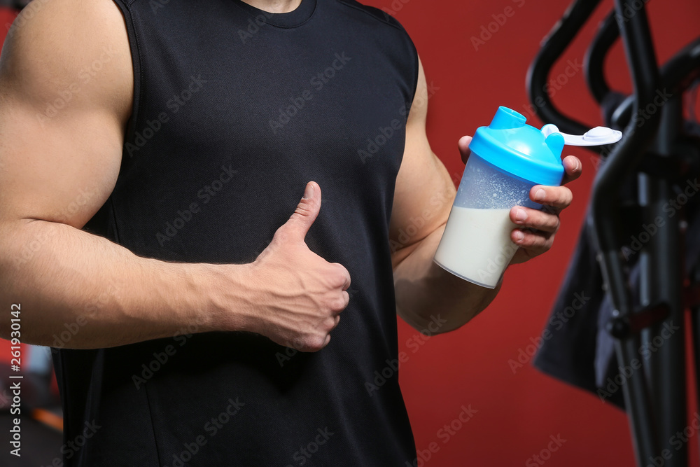 Sporty man with protein shake on color background Stock Photo | Adobe Stock