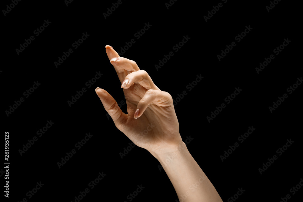 Female hand demonstrating a gesture of getting touch isolated on black ...