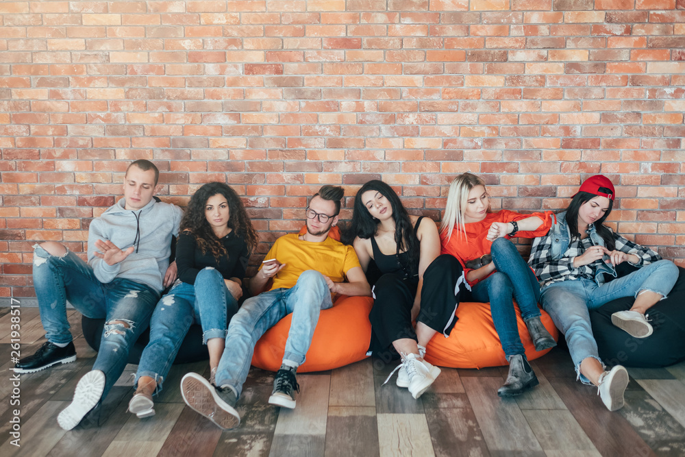 Millennials sitting around doing nothing in lounge zone. Young people ...