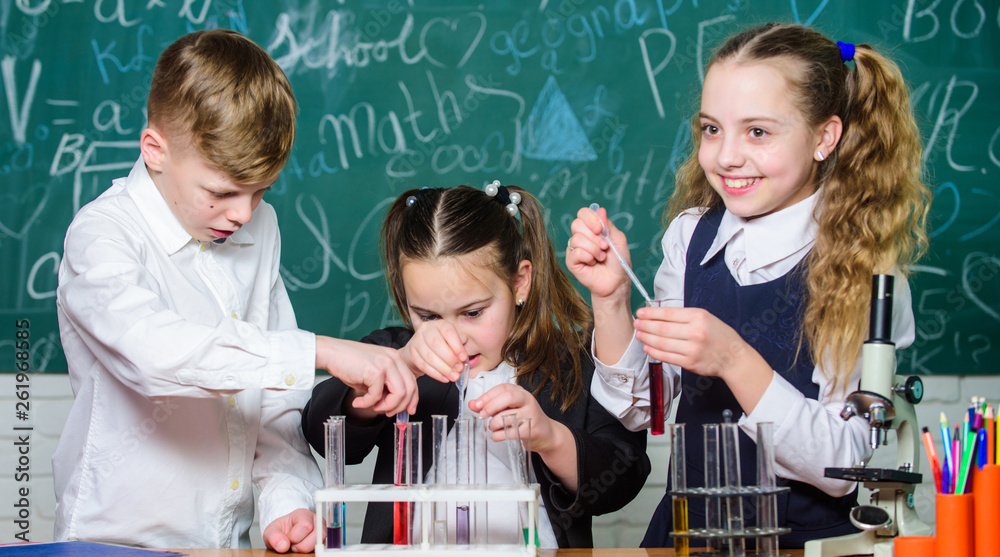 Focusing on work. Little children at laboratory. students doing biology ...