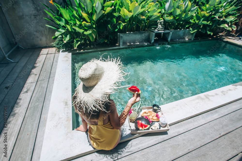 Girl eating fruits in pool on luxury villa in Bali Stock Photo | Adobe ...