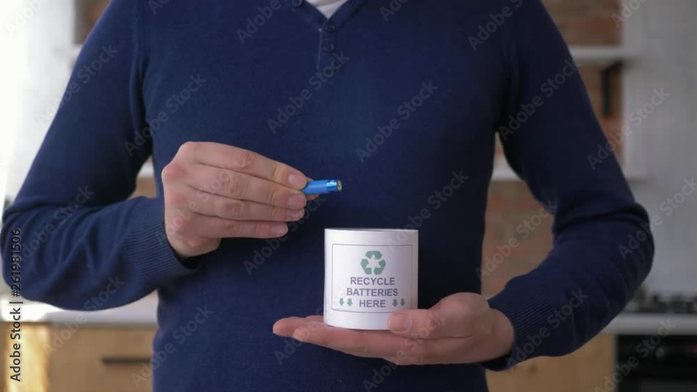 collecting used batteries, man puts old batteries into container with ...