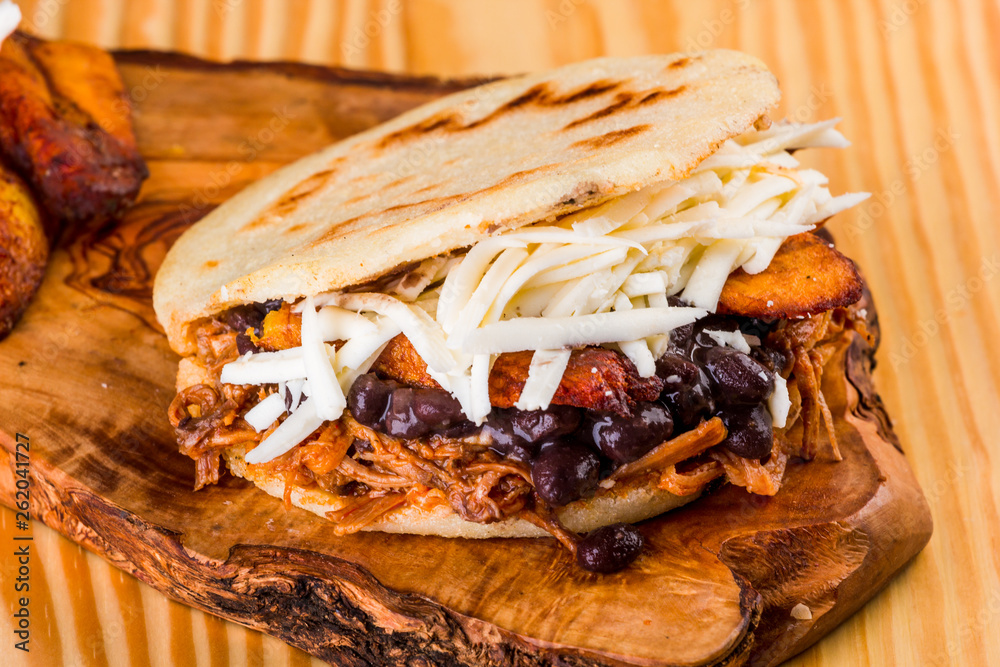 Delicious arepa stuffed with white cheese, fried plantain, roasted meat ...