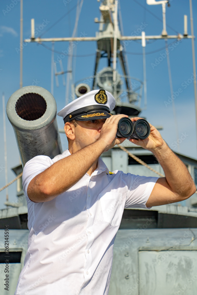 Captain of warship standing beside cannons and watching the ...
