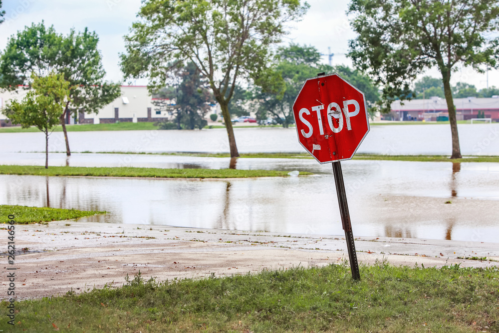 A stop sign at the edge of stormwater filling a flooded street Stock ...