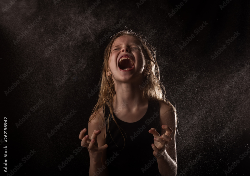 young girl with live emotions dancing under water drops. child ...