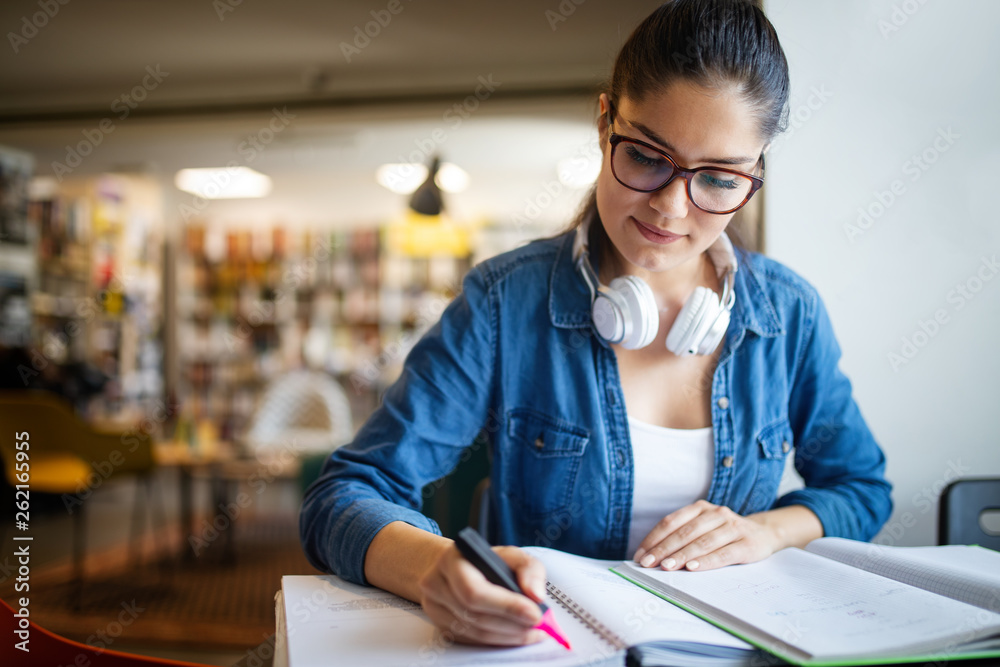 Beautiful student girl learning in a library Stock Photo | Adobe Stock