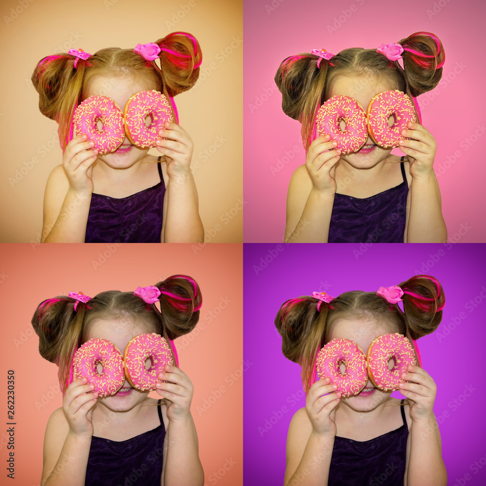 A little kid girl dabbles and plays with two fresh donuts before eating ...
