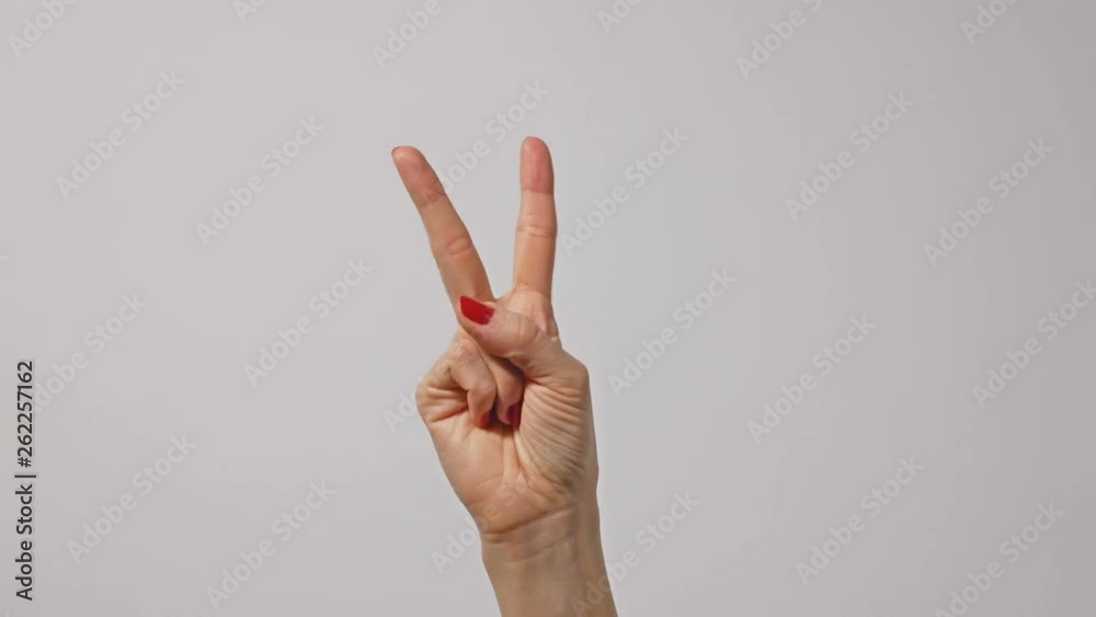 Woman raising two fingers up and showing peace or victory symbol or ...