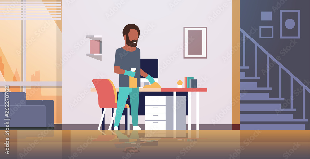 man cleaning computer table with duster african american guy wiping ...
