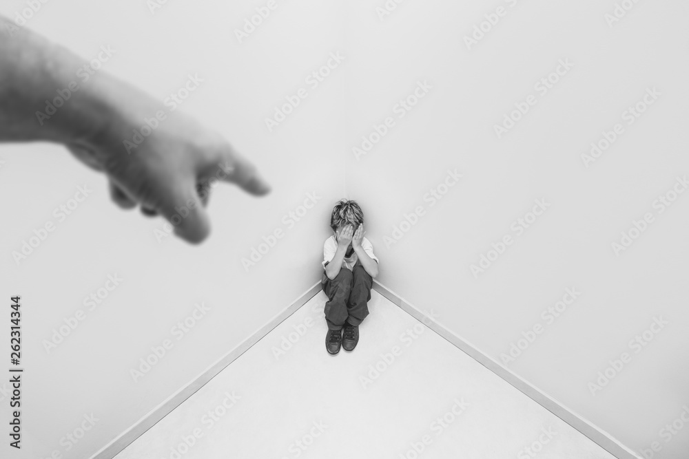 Adult hand pointing at child in school uniform crying, concept of child ...