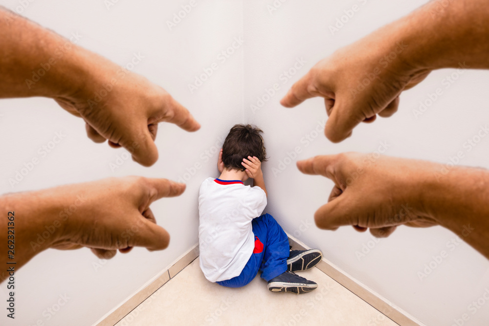 Adult hand pointing at child in school uniform crying, concept of child ...