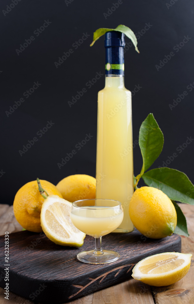 Lemoncello in a bottle on a black background, Traditional Italian ...