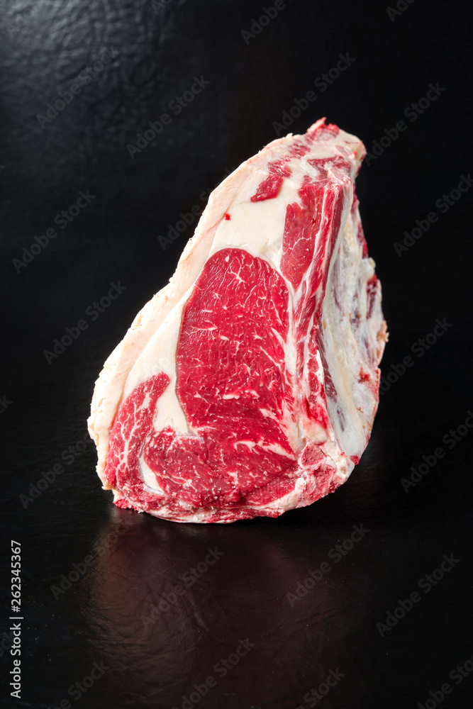 Raw dry aged wagyu cote de boeuf beef block as closeup on black ...
