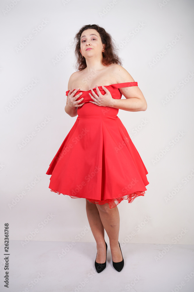 plump woman in a red pinup dress. chubby fashionable girl standing on ...