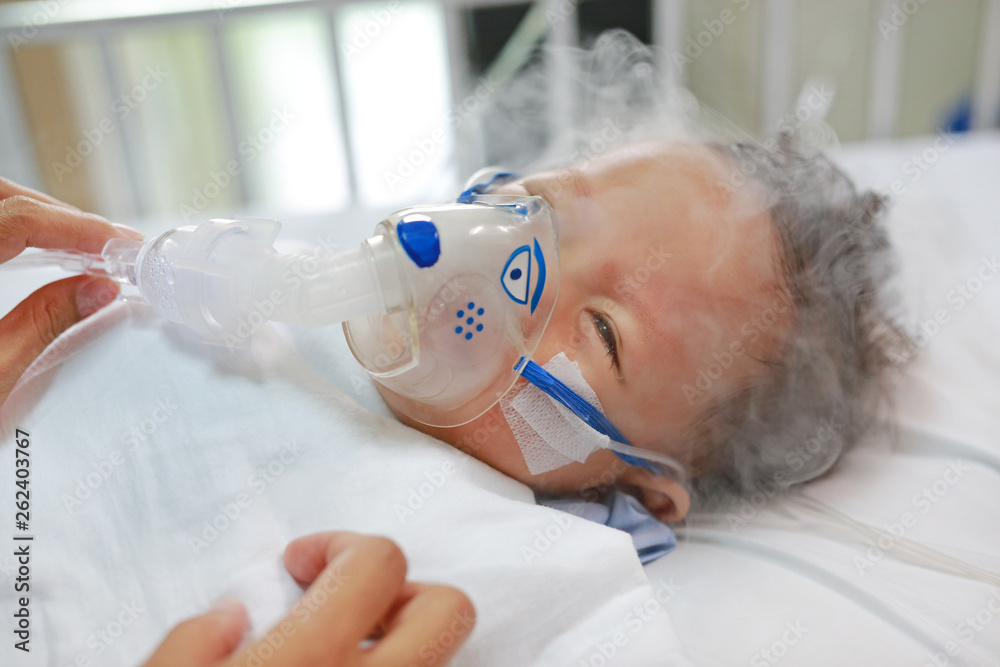 Sick baby boy and has inhalation therapy by the mask of inhaler on ...