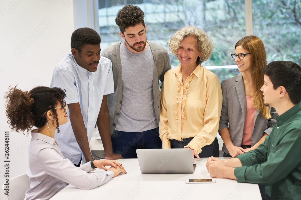 Software Entwickler Team schaut auf einen Laptop Stock Photo | Adobe Stock