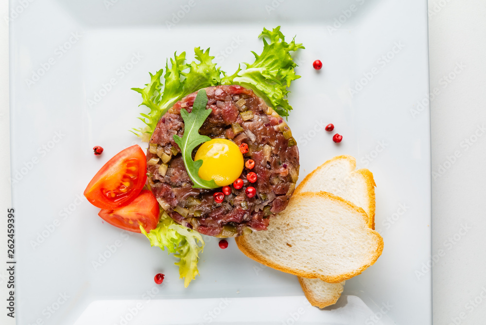 French cuisine, beef steak tartare with raw quail egg yolk Stock Photo ...