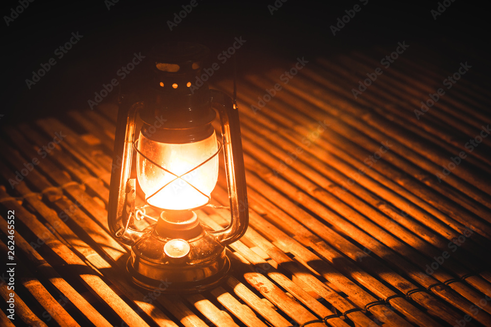 Burning kerosene old lamp on bamboo wooden, lighting in camping night ...