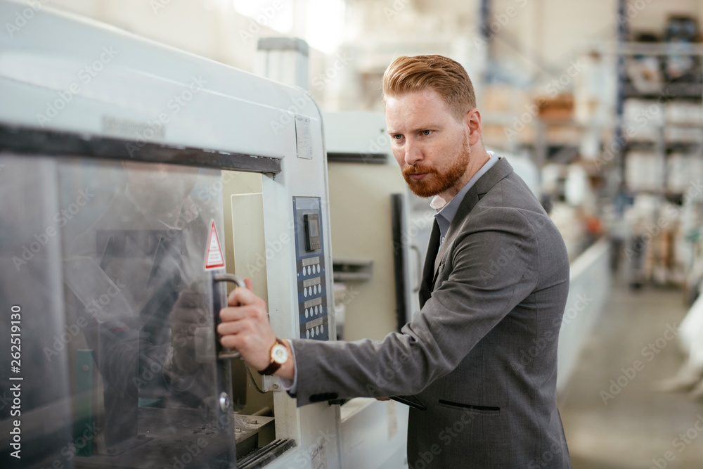 Manager checks machines at the factory. Supervisor runs his daily check ...