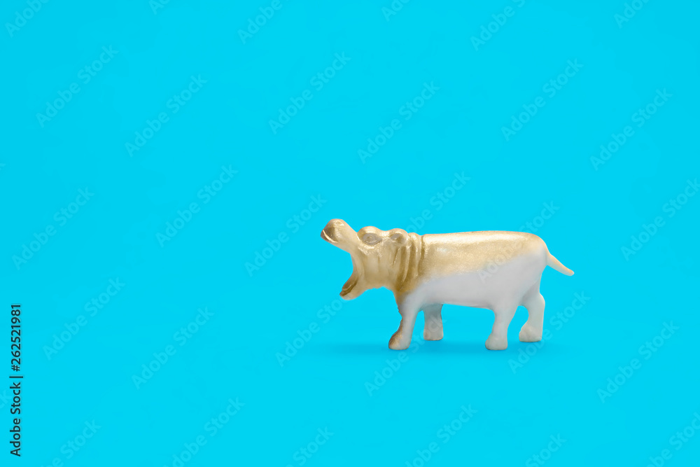 Plastic hippo with open mouth, isolated on blue background. With ...