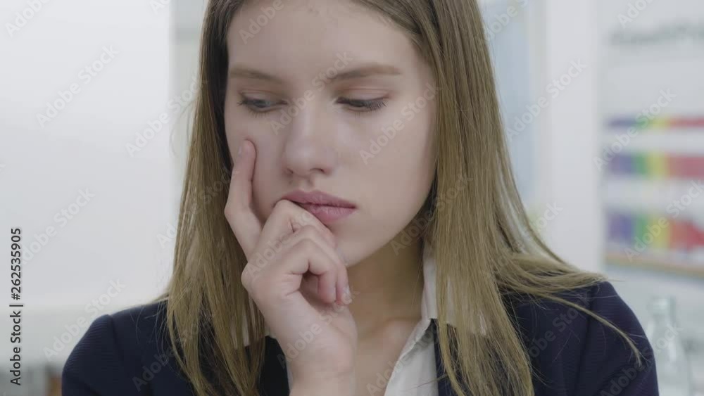 Close up portrait of concerned sad young lady in formal clothes looking ...