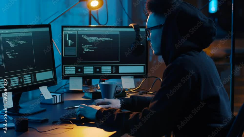 cybercrime, hacking and technology concept - asian male hacker in ...