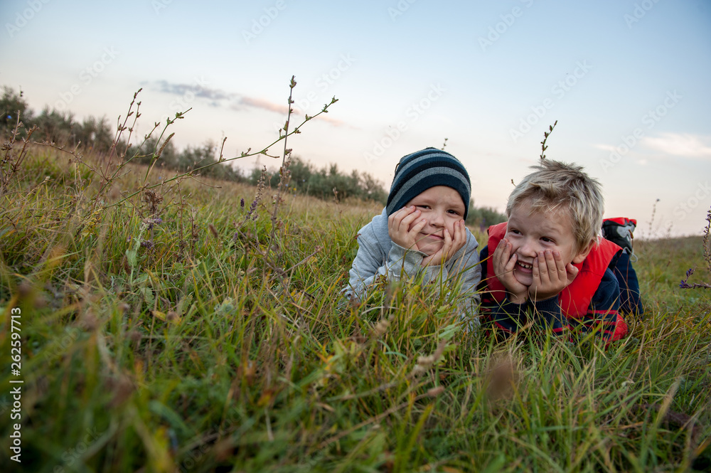 happy children playing in field sown with winter wheat against backdrop ...