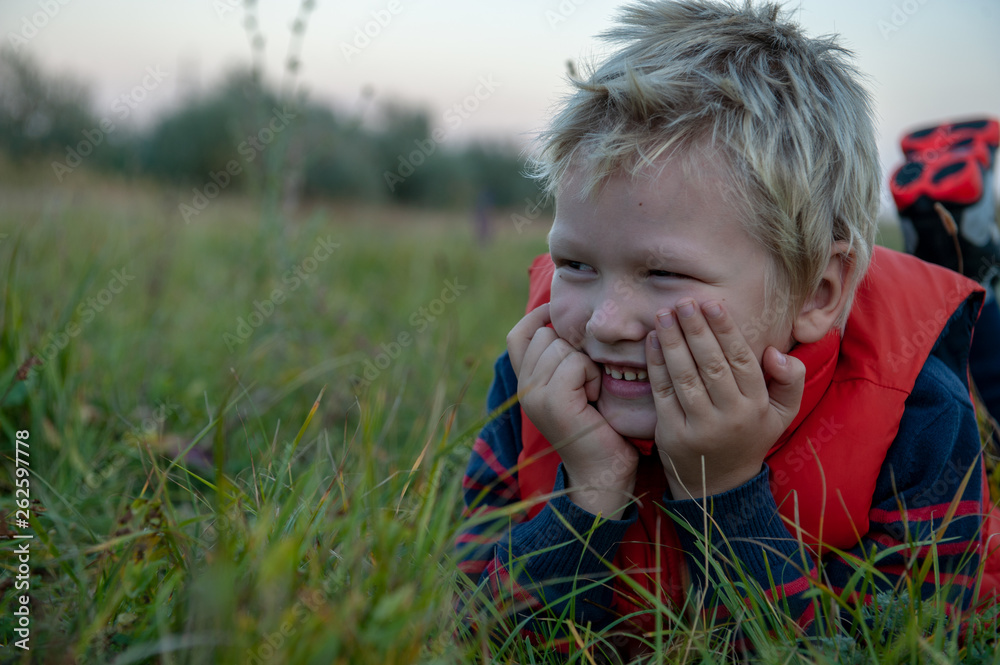 happy child playing in field sown with winter wheat against backdrop of ...
