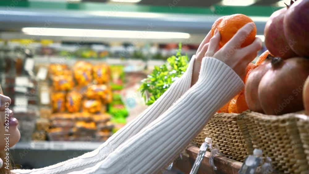 woman in the fruit market with orange in hand. fruits and vegetables. a ...