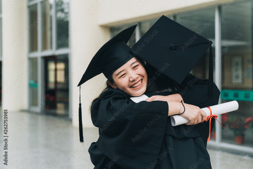 Hugging female best friend. two happy asian girl students in graduate ...