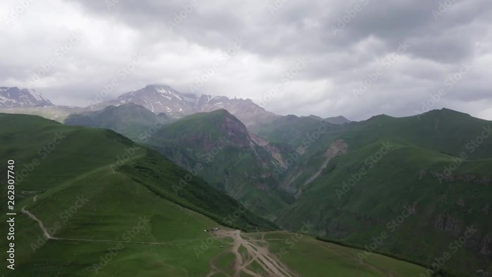 Top view of the high ridge of mountains. Near the mountains are green ...