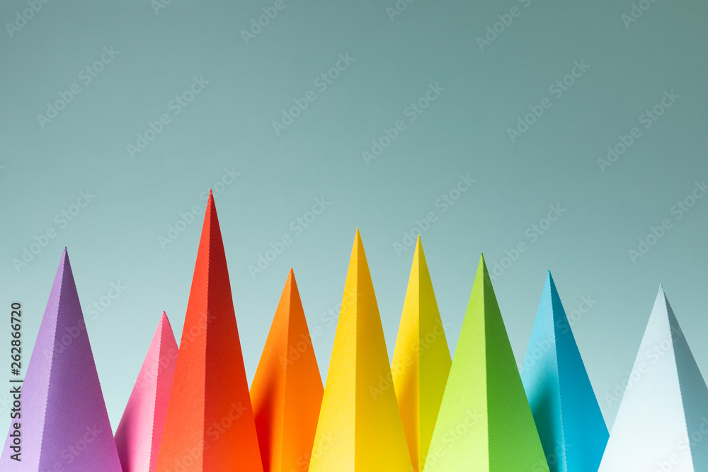 Rainbow pyramid shapes arranged on a bright blue background. (3) Stock ...