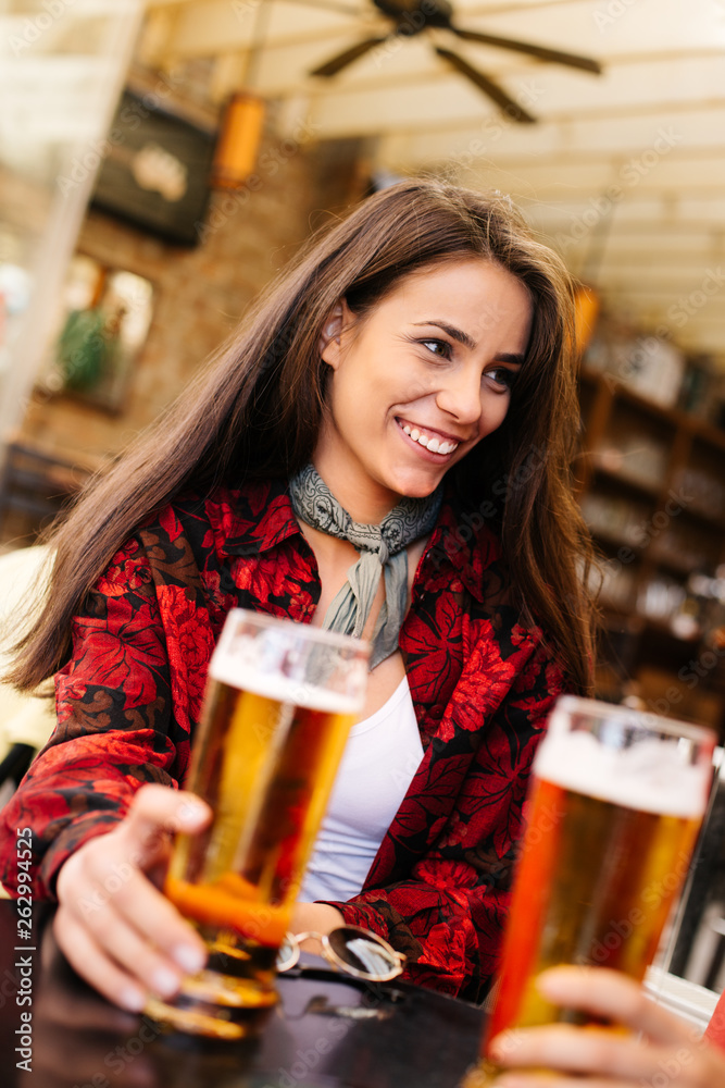 Girl having a beer while waiting for a friend. Long haired woman ...