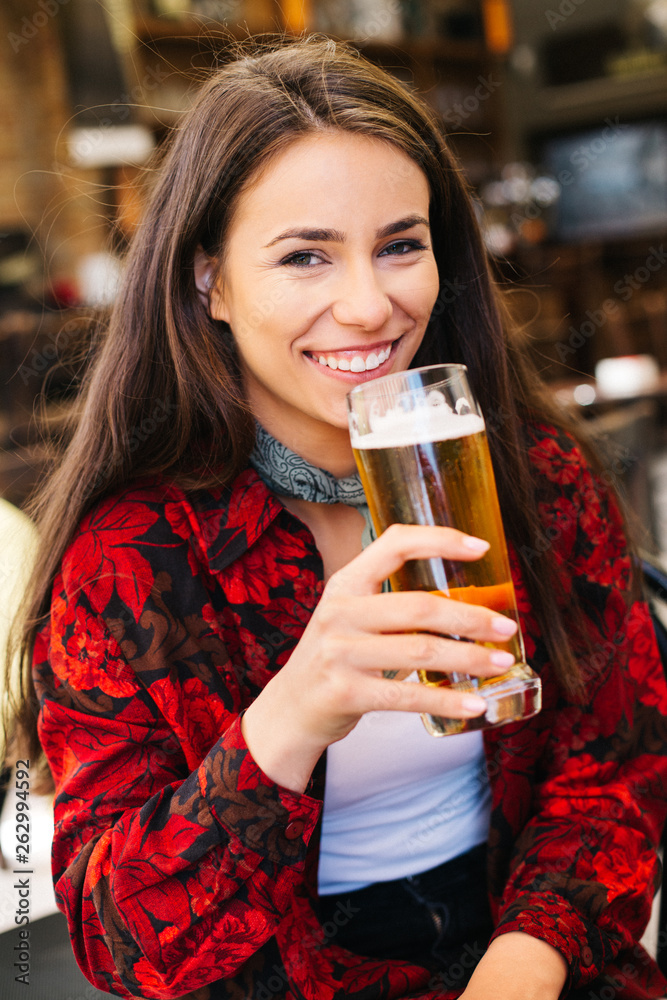 Girl having a beer while waiting for a friend. Long haired woman ...