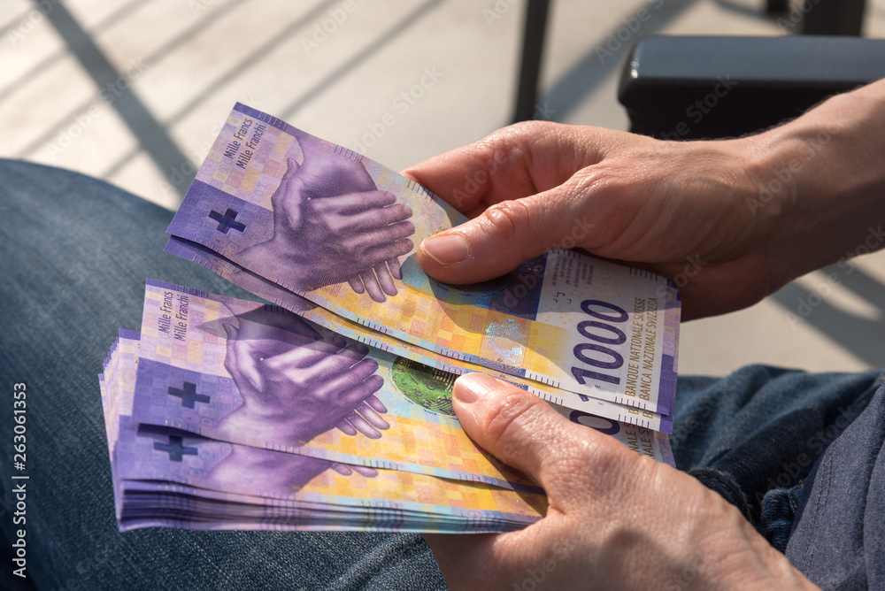 Photo & Art Print hands holding a stack of 1000 Swiss francs banknotes ...