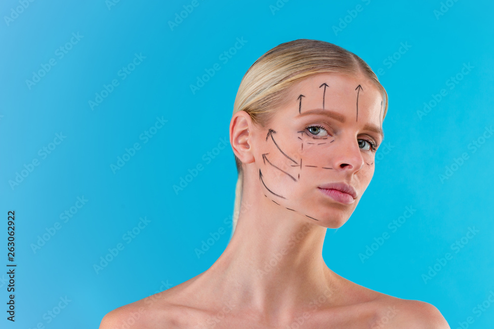 Beautician draw correction lines on woman face. Before plastic surgery ...