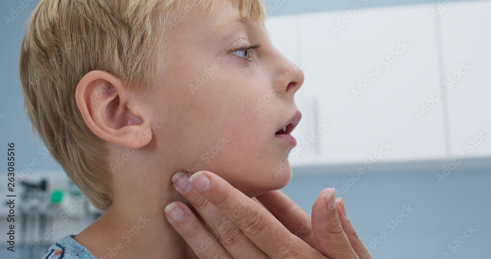 Close up of pediatrician checking swollen lymph nodes on sick child ...