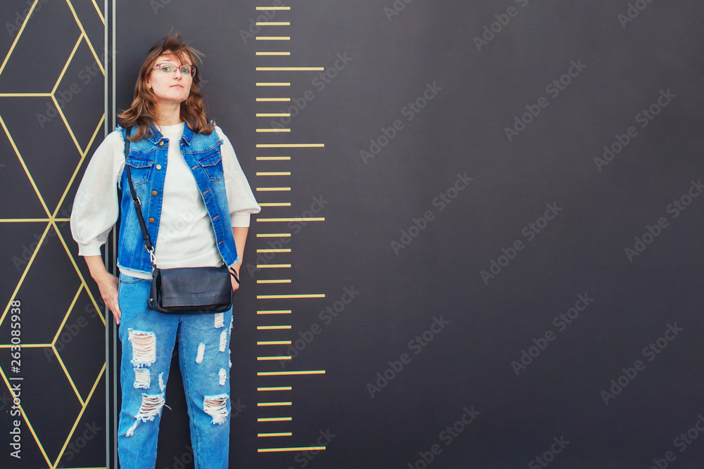 Girl stands next to a large scale ruler. Measurement of a woman in full ...