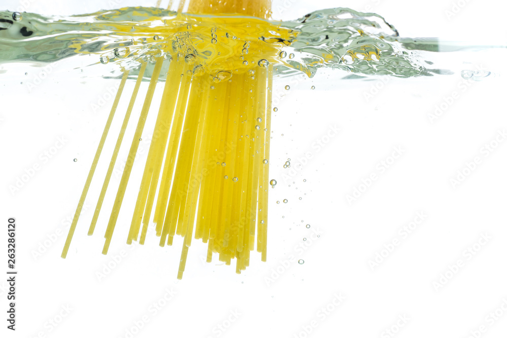 cooking pasta spaghetti falling into boiling water and splash on white ...