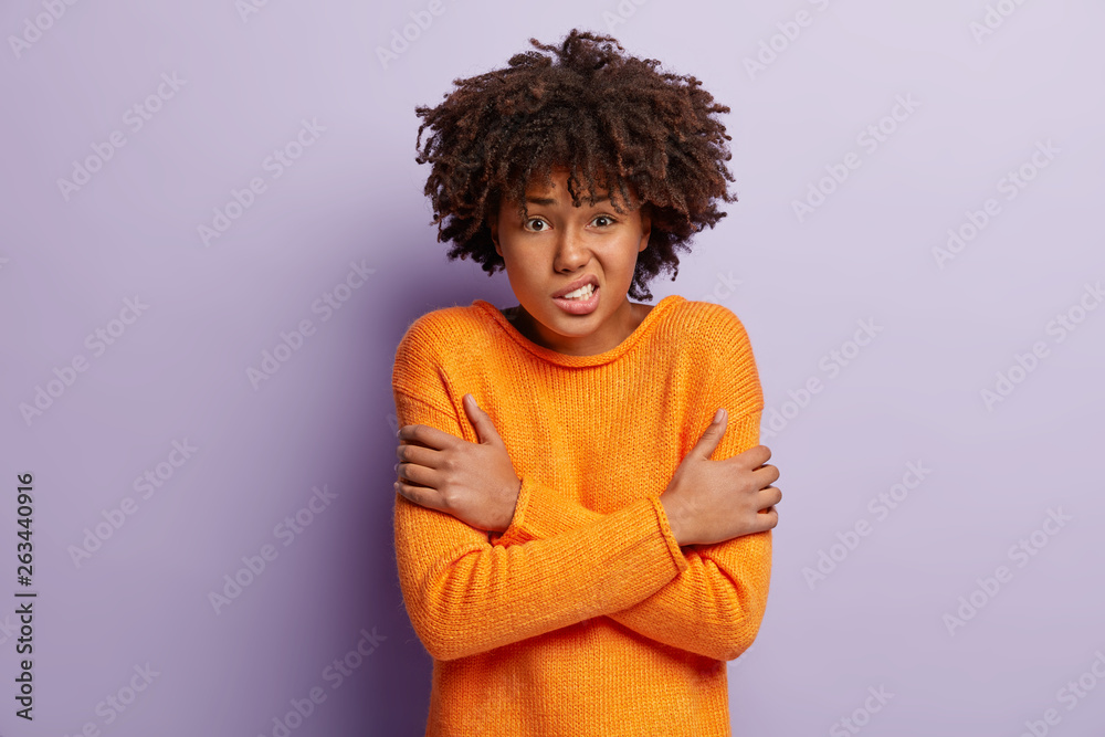 Scared woman trembles from fear, crosses hands over chest, feels ...