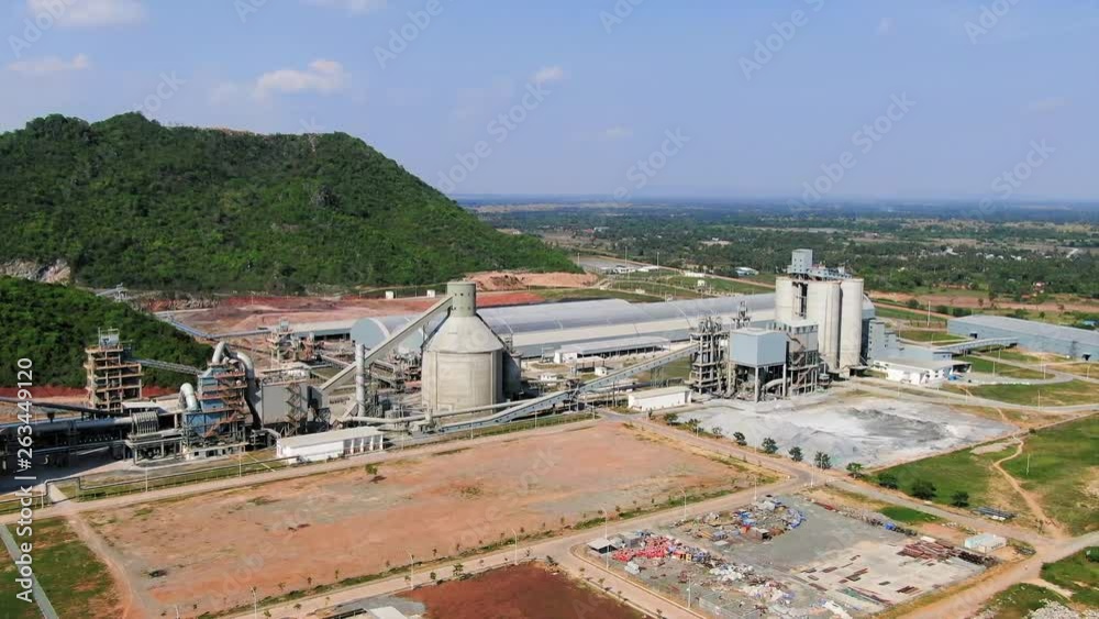 Aerial view fly toward a large industrial concrete manufacturing plant ...