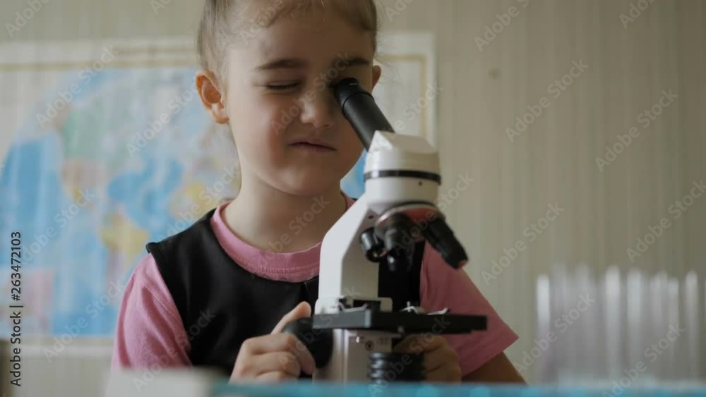 Little girl in science lab study samples under microscope. Schoolgirl ...
