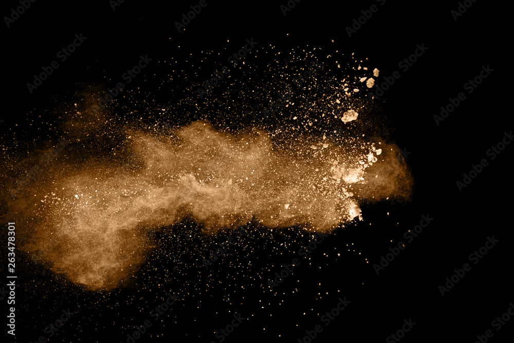 Brown particles splattered on black background. Brown dust splashing ...