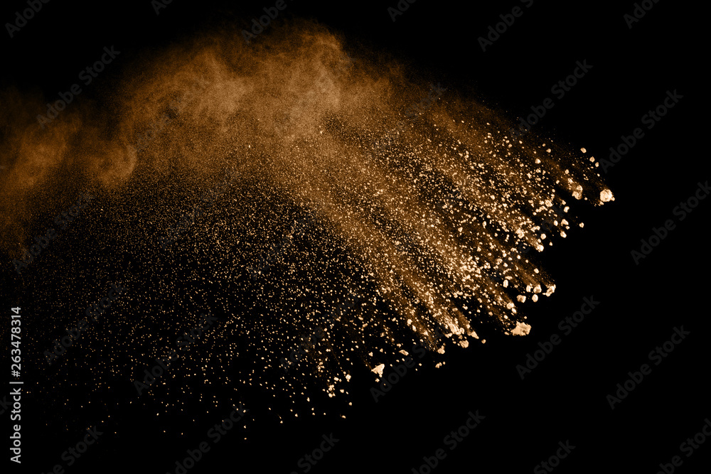 Brown particles splattered on black background. Brown dust splashing ...