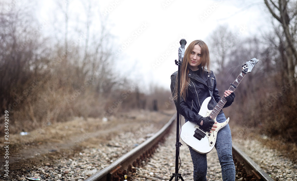 Beautiful young girl rocker with electric guitar. A rock musician girl ...